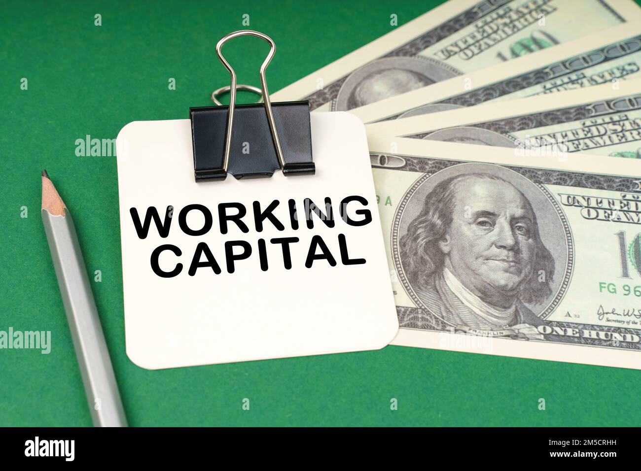 Business concept. On a green surface, a pen, dollars and in a clip ...