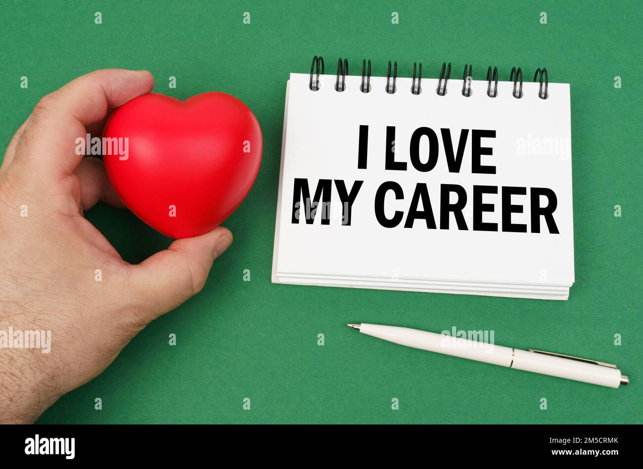 On the green surface are a pen, a notepad with the inscription - I love ...