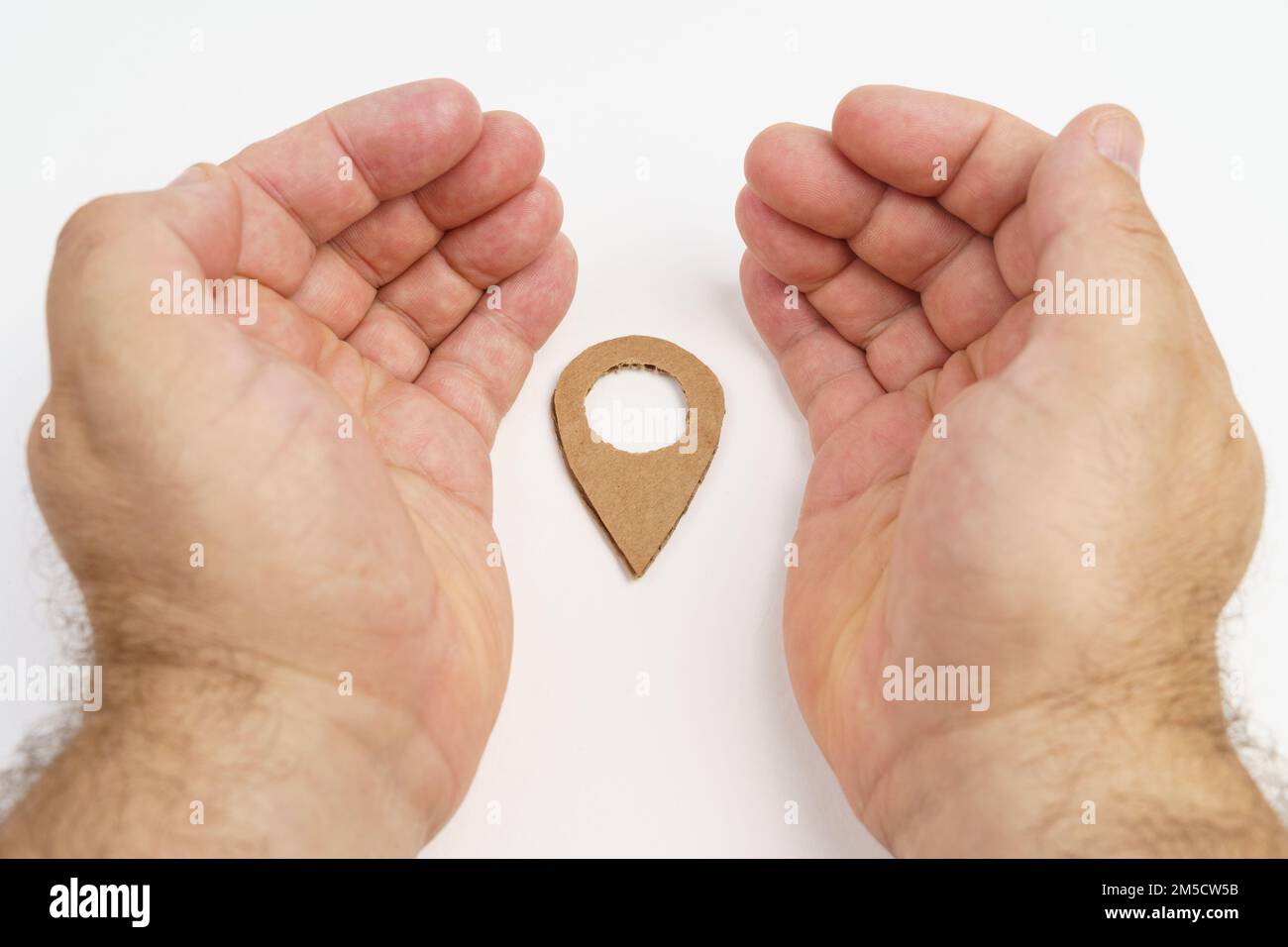 Between the hands of a person on a white background lies a symbol of ...