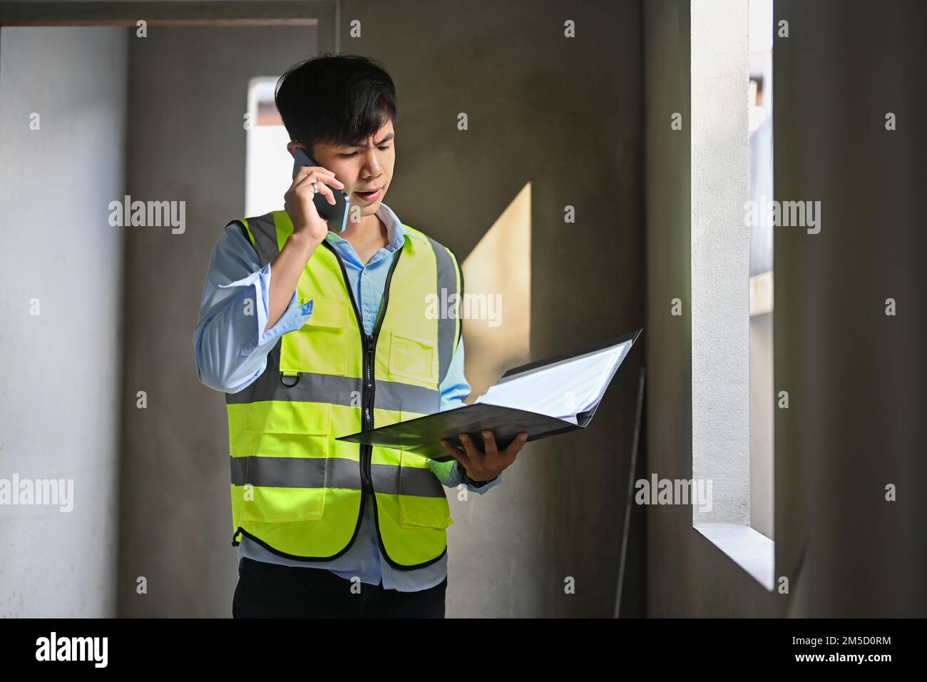 Engineer man in reflective vest standing in construction site and ...