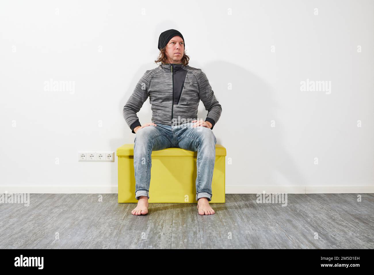 Man sitting on a green box Stock Photo - Alamy