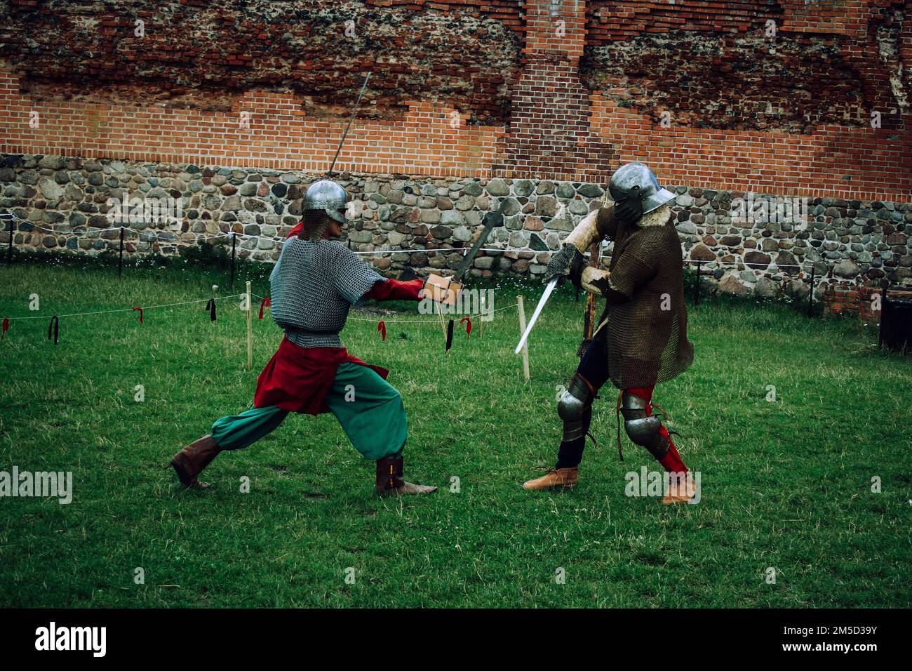Sword fight of two knights in helmets and chain mail armor in scenery ...