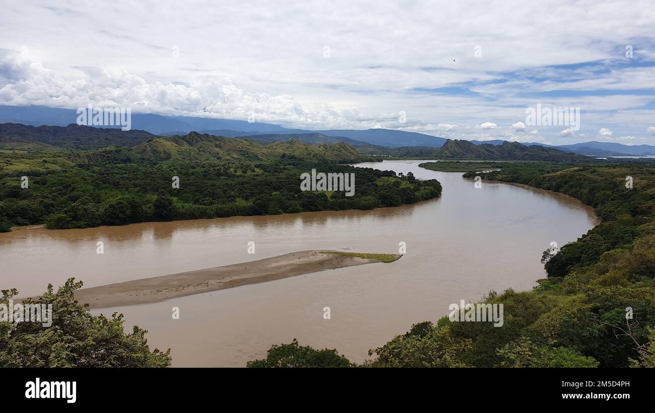 A landscape of the Magdalena River surrounded by greenery and hills ...