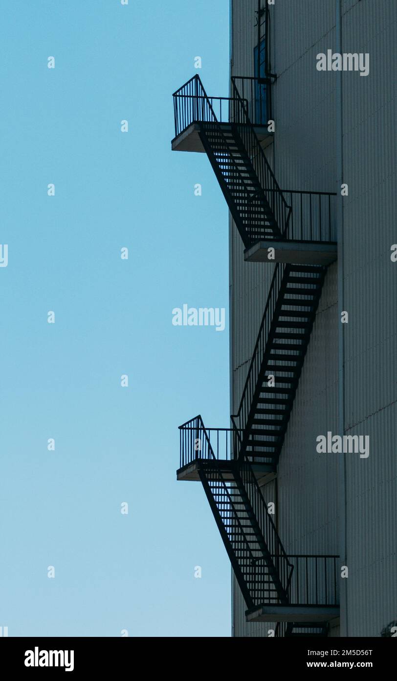 A vertical shot of fire escape ladder on a modern industrial building ...