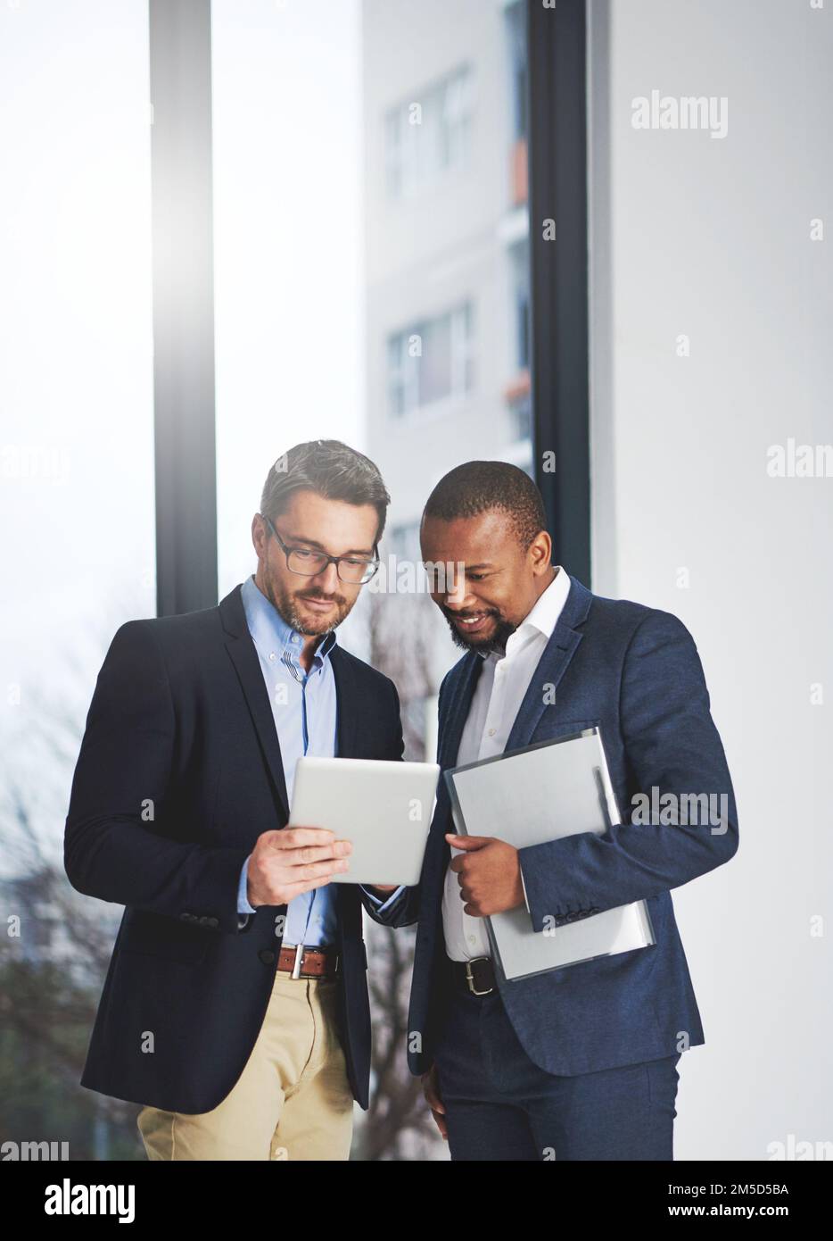 Increasing productivity with business savvy apps. two businessmen using ...