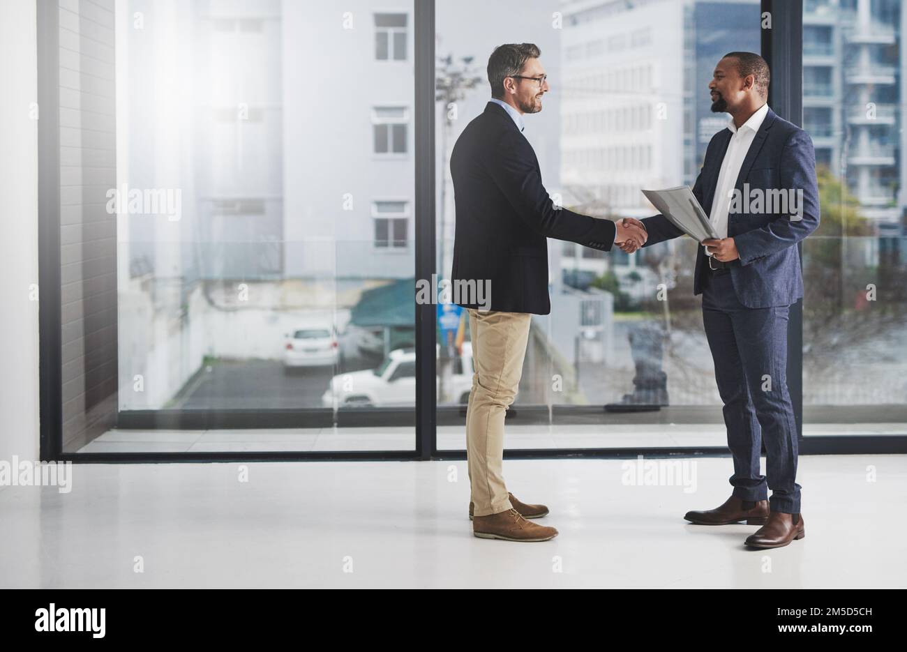 Building a business together. two businessmen shaking hands at work ...