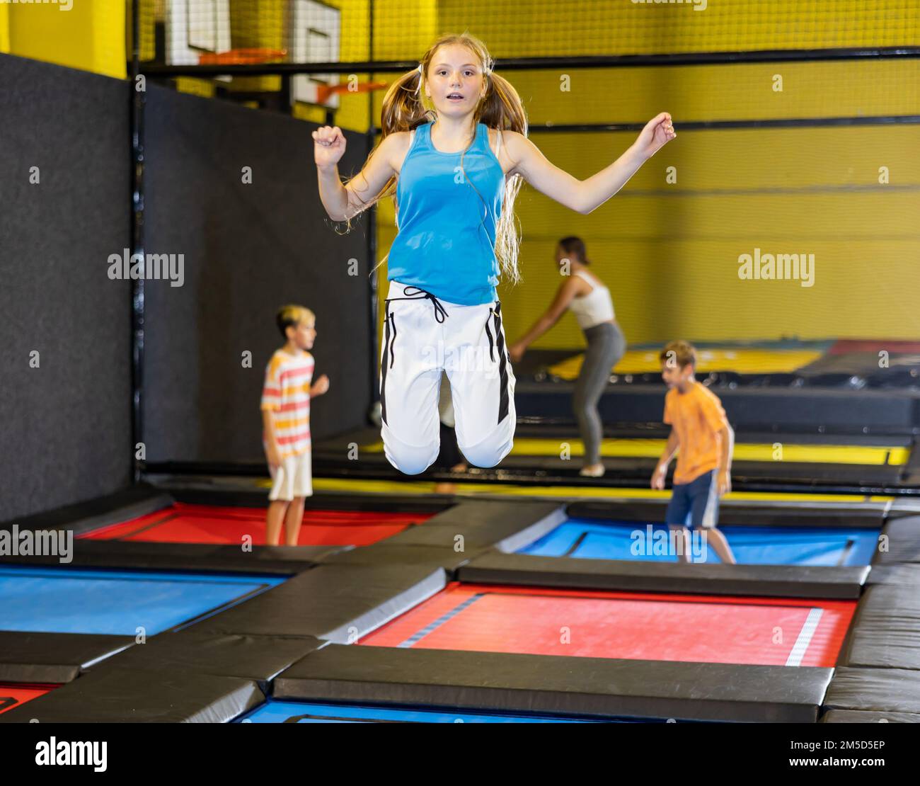 Teenage girl having fun jumping in indoor trampoline arena Stock Photo ...