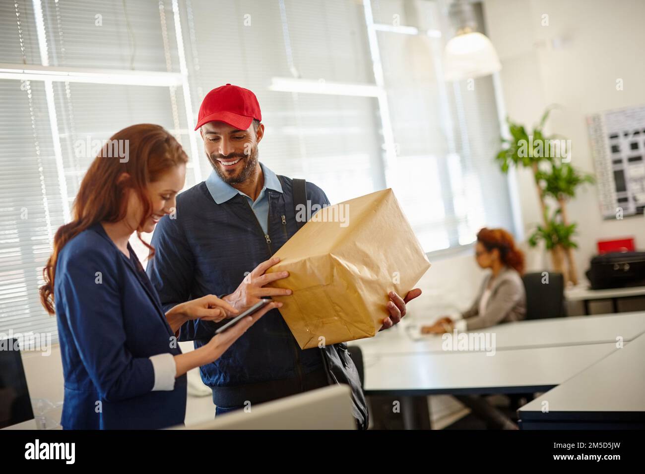 Right on time as always. a young woman receiving a package from a ...