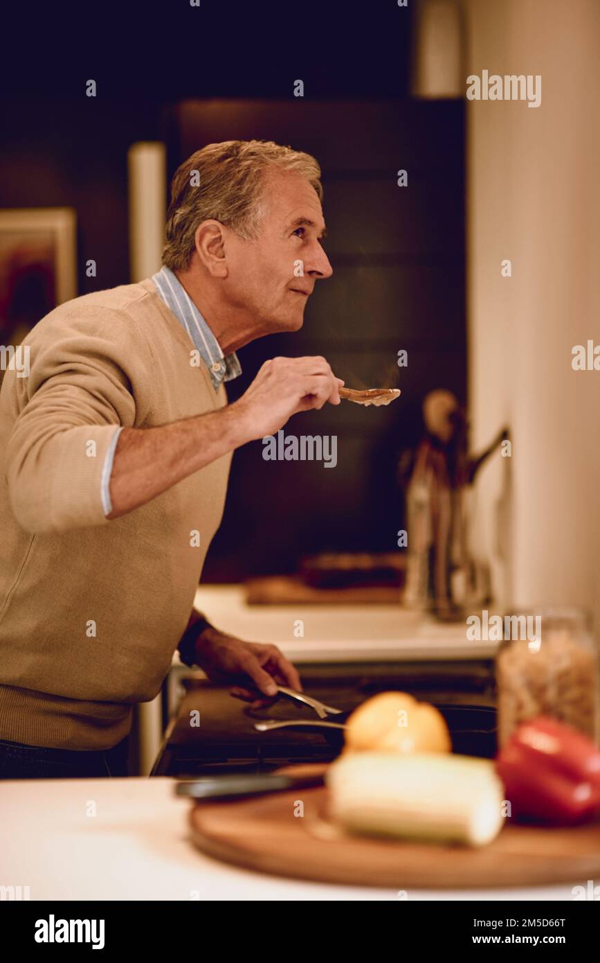 Its missing something, but what could it be. an elderly man cooking a ...