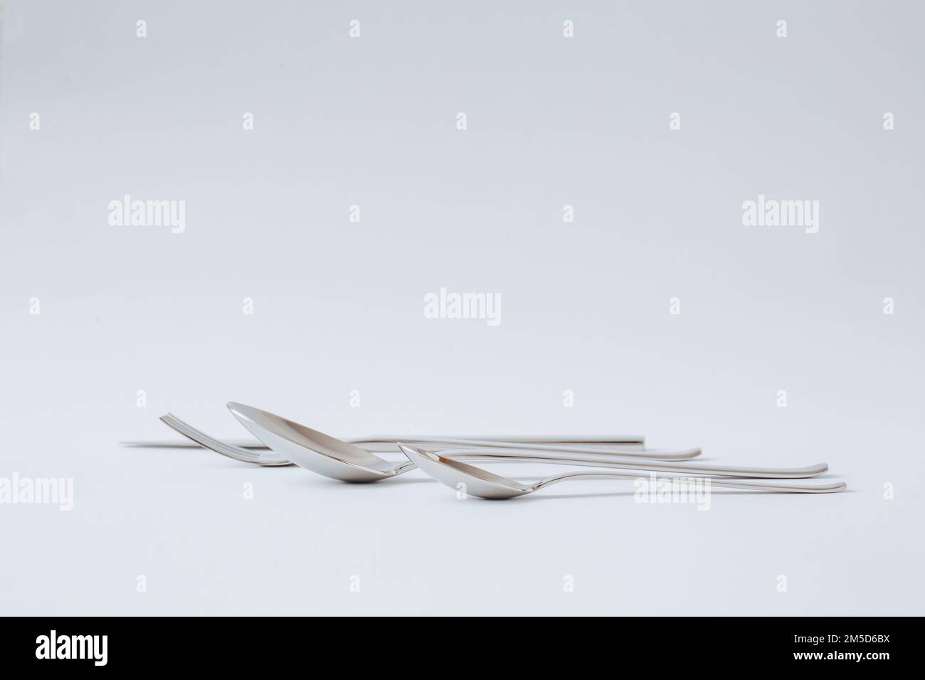 Stainless steel cutlery set, knife, spoon, fork, teaspoon on a white ...