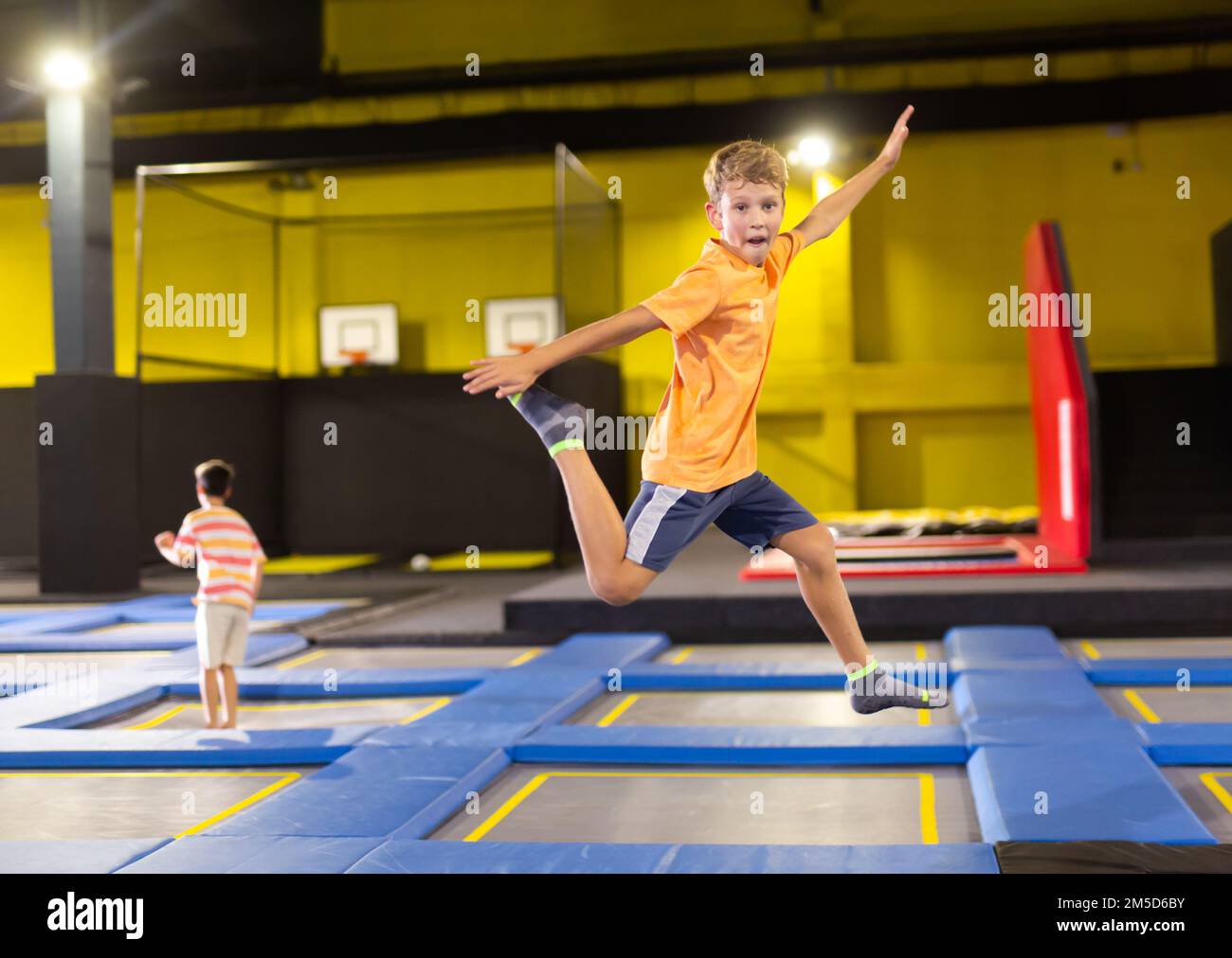 Preteen boy bouncing on trampoline in indoor amusement park Stock Photo ...