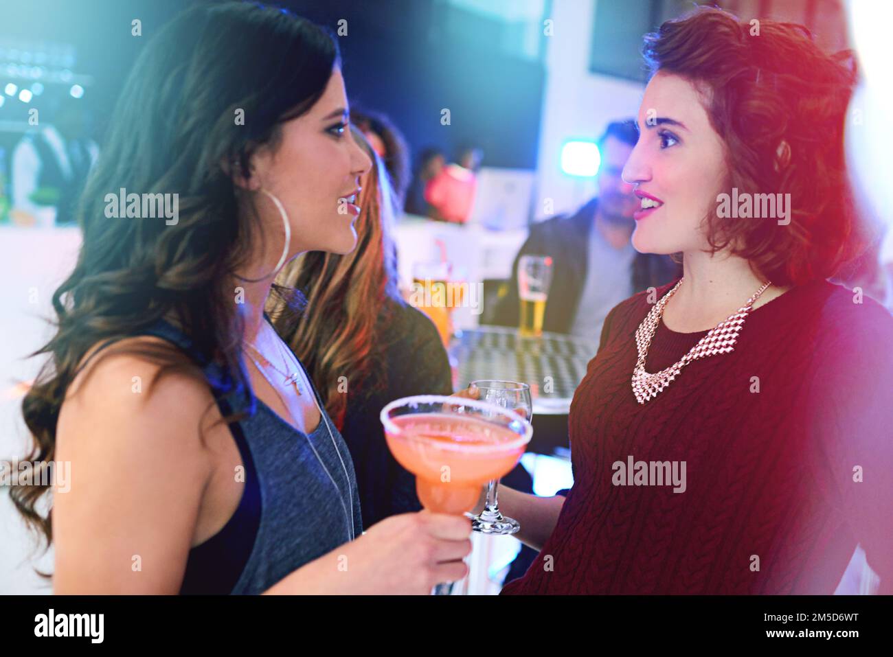 Catching up over cocktails. two young women having cocktails at a ...