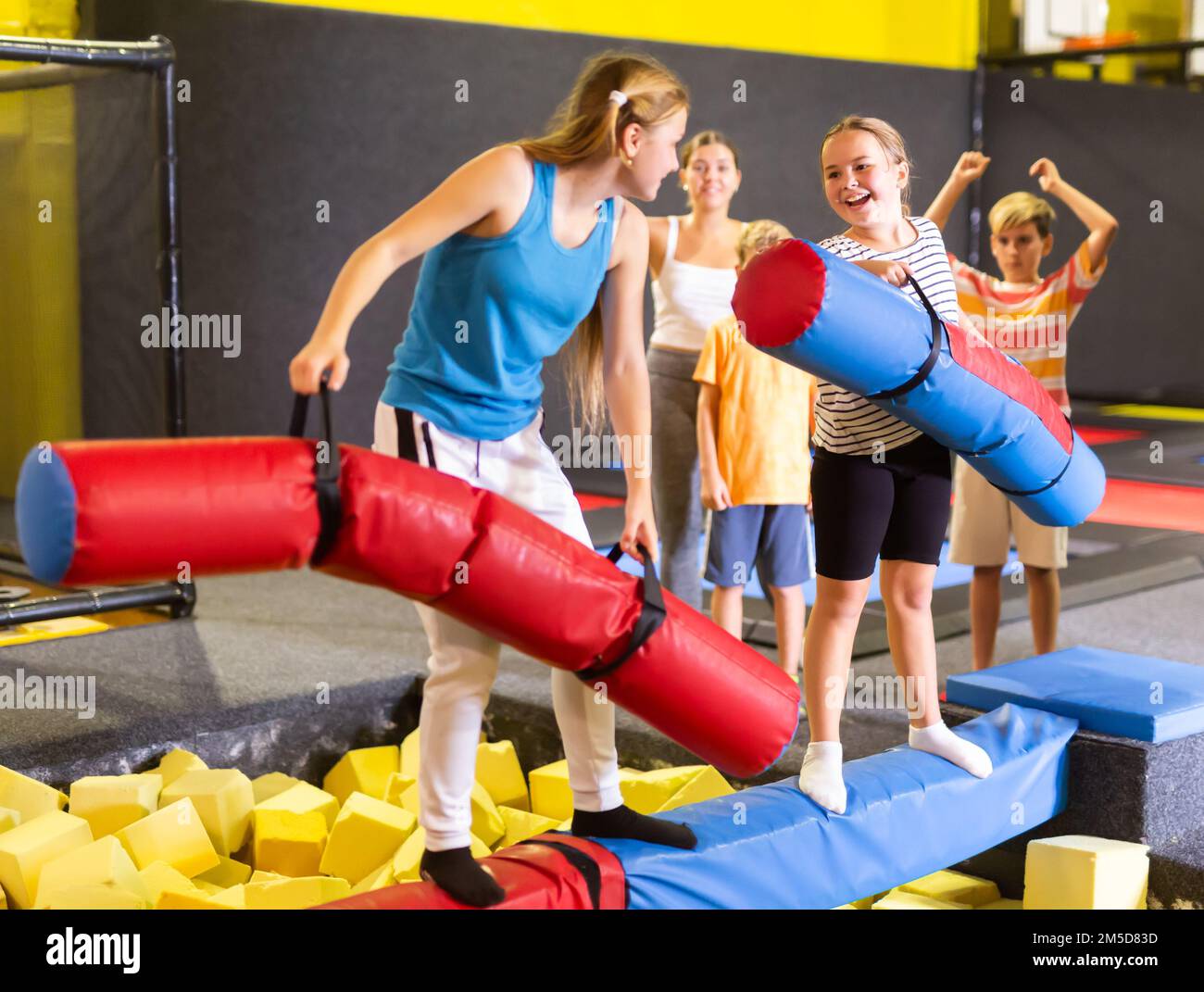 Children having funny wrestling by inflatable logs with his friends in ...