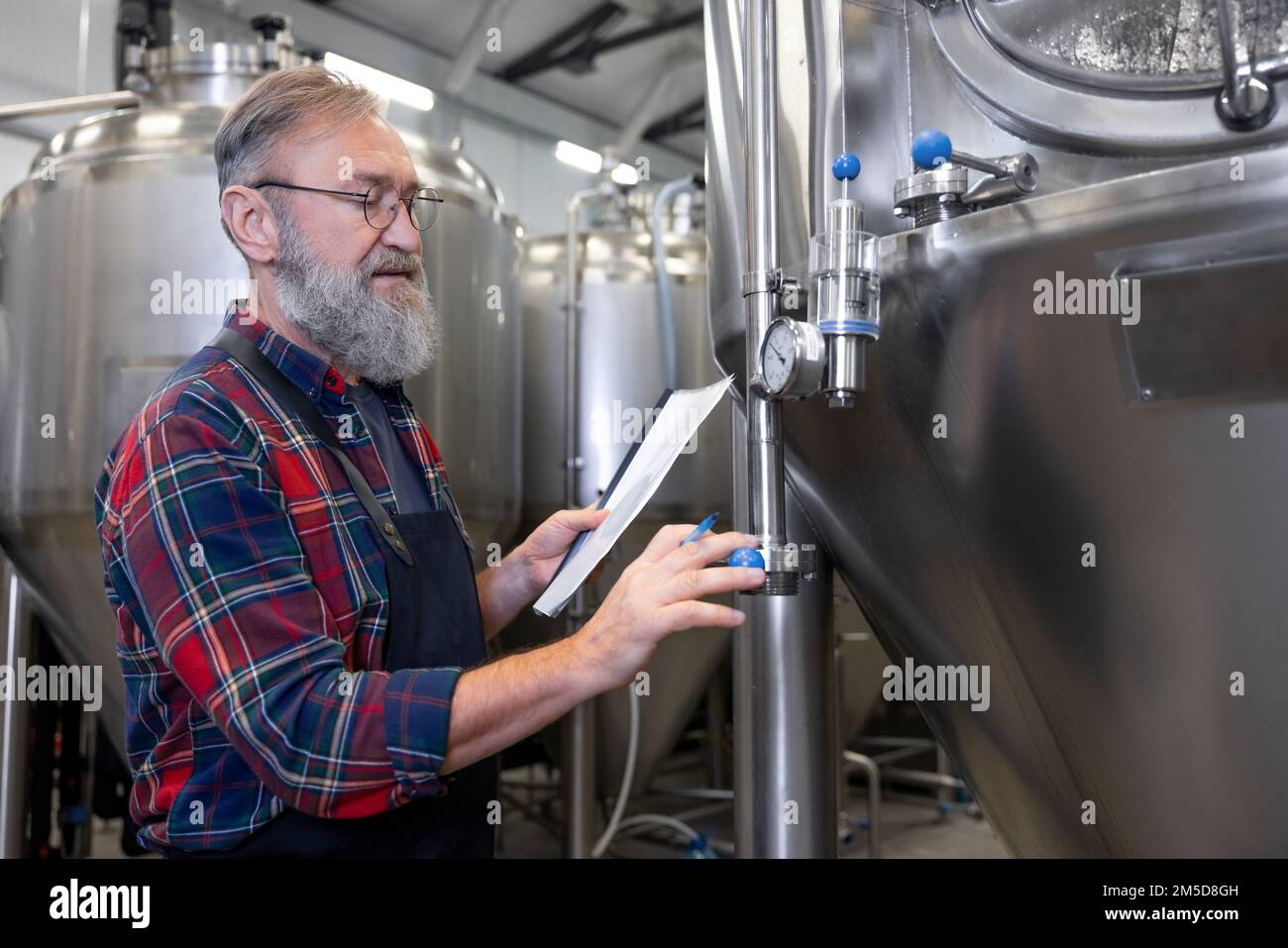 Brewery worker checking the pressure in tanks with beer Stock Photo - Alamy