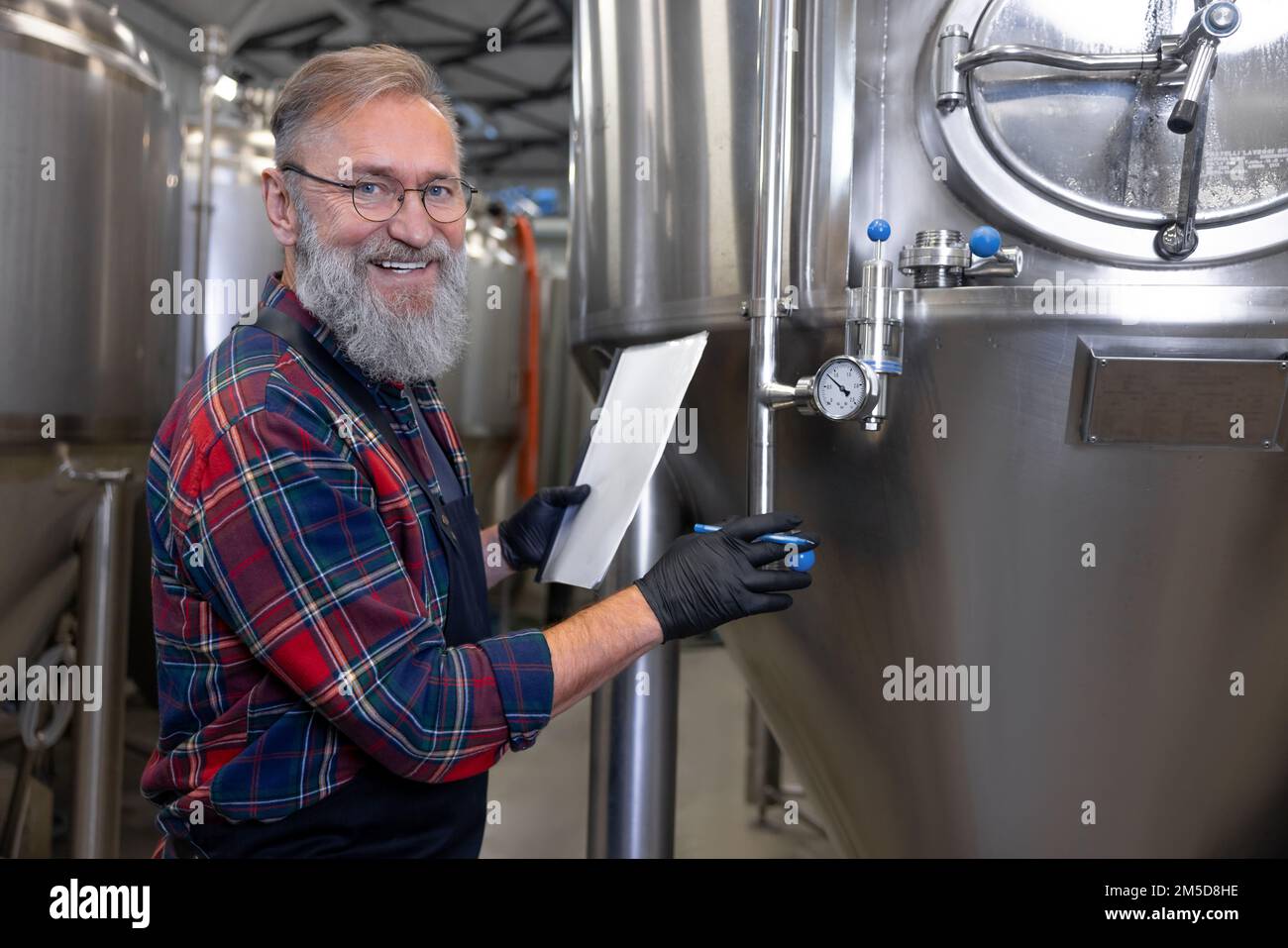 Brewery worker checking the pressure in tanks with beer Stock Photo - Alamy