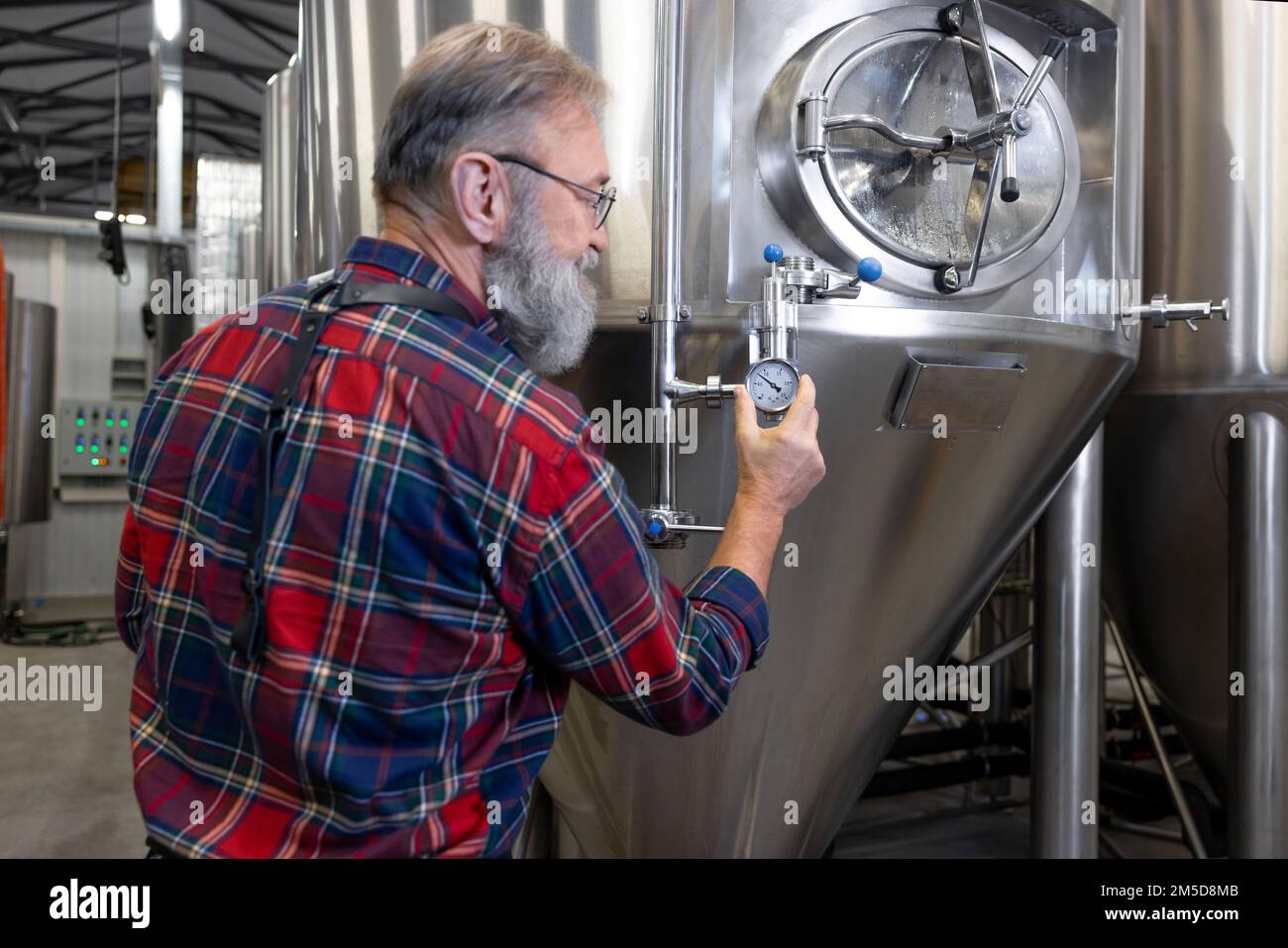 Brewery worker controlling the pressure in tanks with beer Stock Photo ...