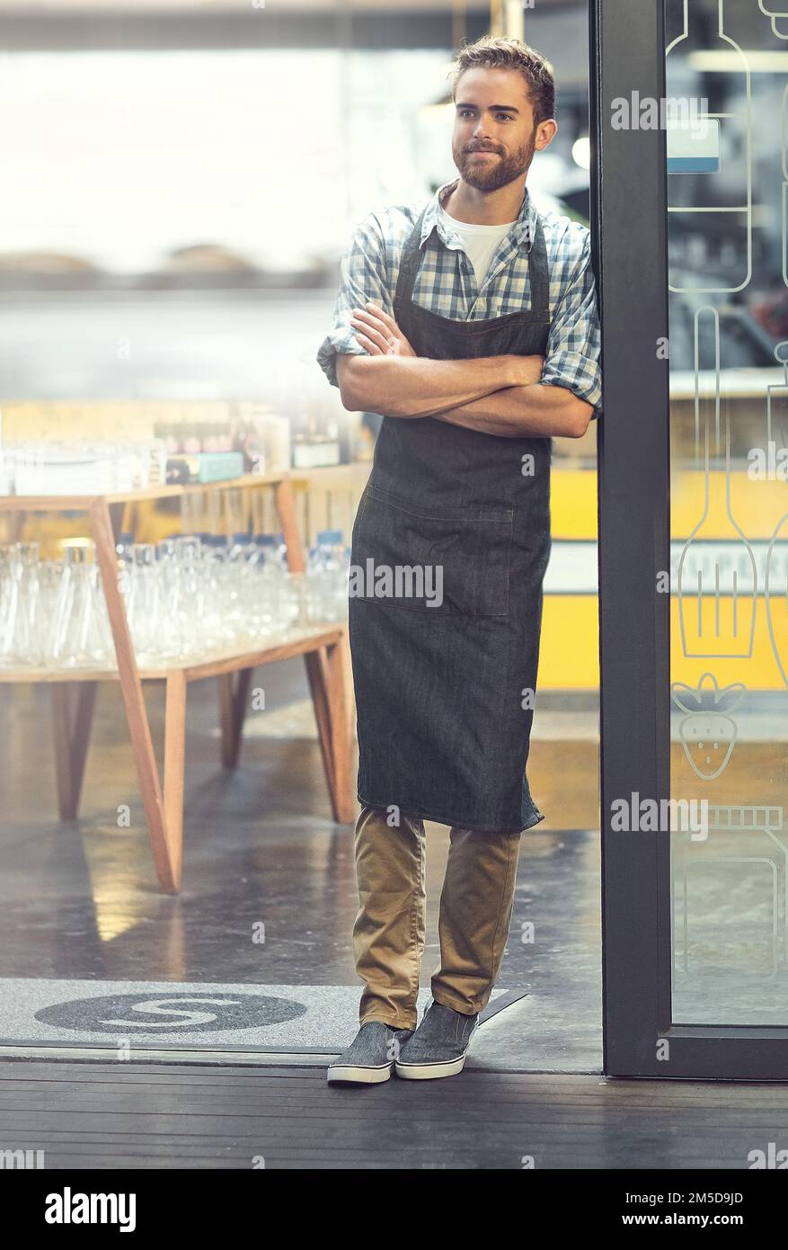 His doors are open for business. a confident young man working standing ...