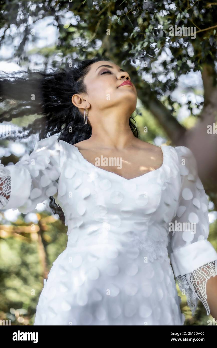Attractive Sri Lankan female wearing white dress and posing in the park ...