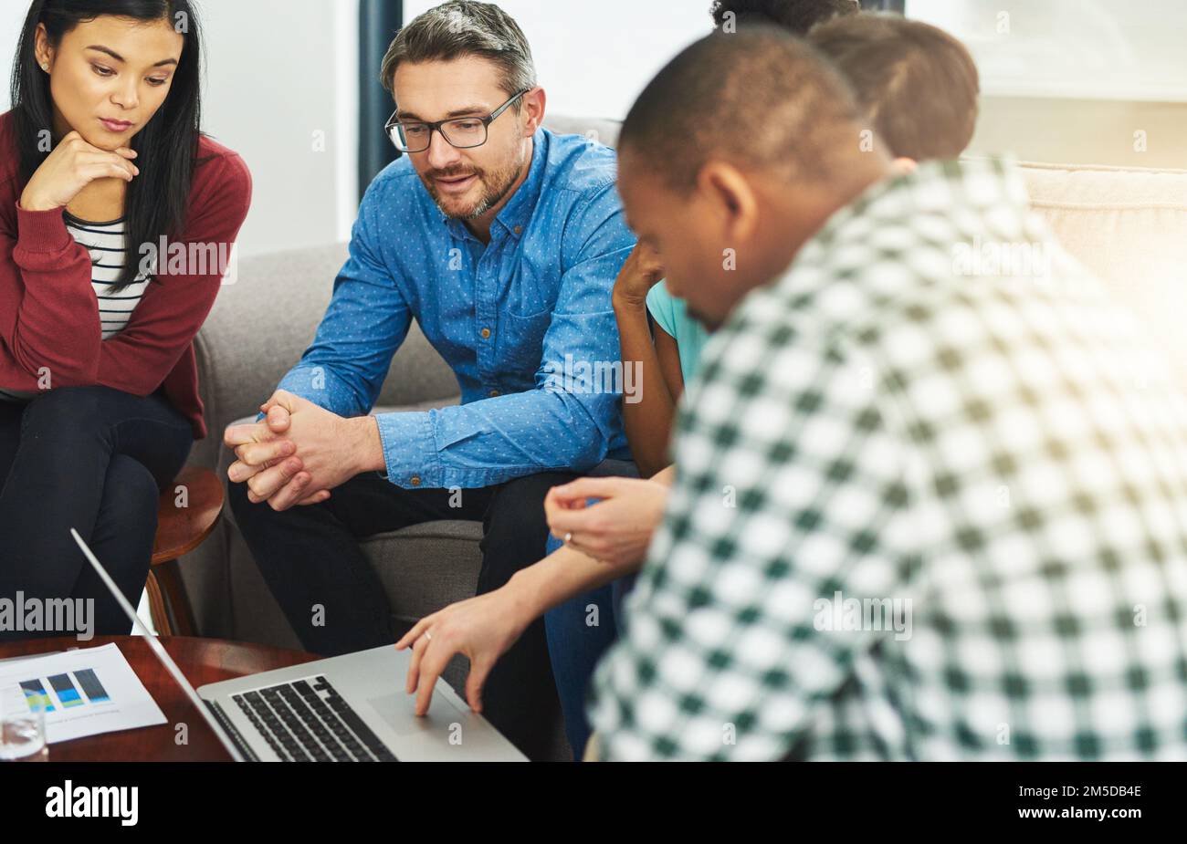 Making ideas happen. a group of colleagues working together on a laptop ...