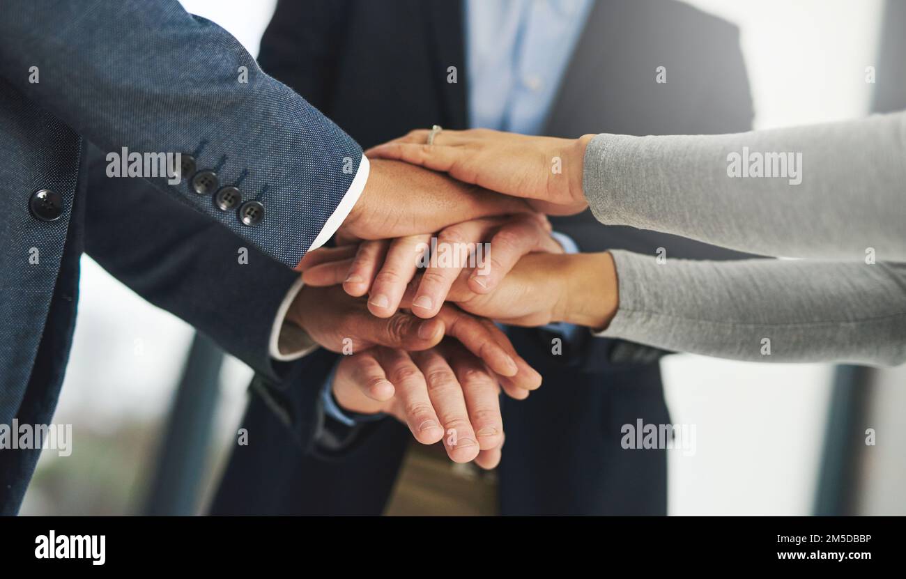 Putting teamwork into action. a team of colleagues joining their hands ...