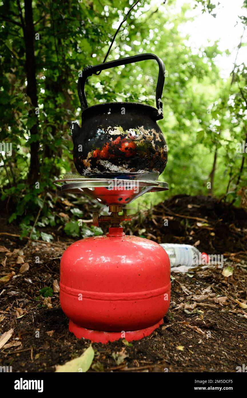 Heating water with a gas cylinder in the forest during a rest in the ...