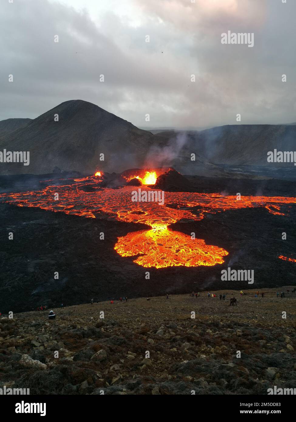A volcano with lava pouring into the air from a crater Stock Photo - Alamy