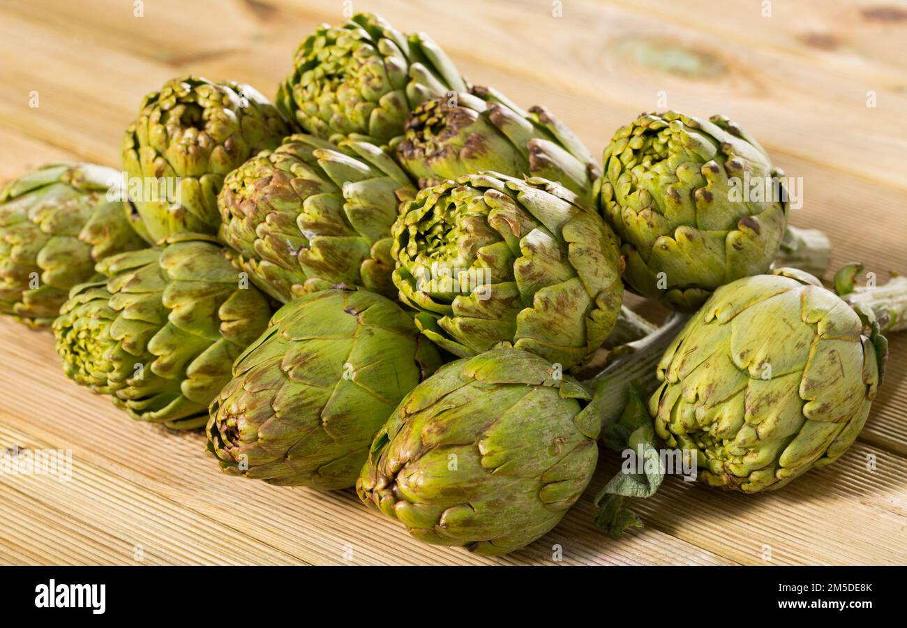 Artichokes on wooden table Stock Photo - Alamy