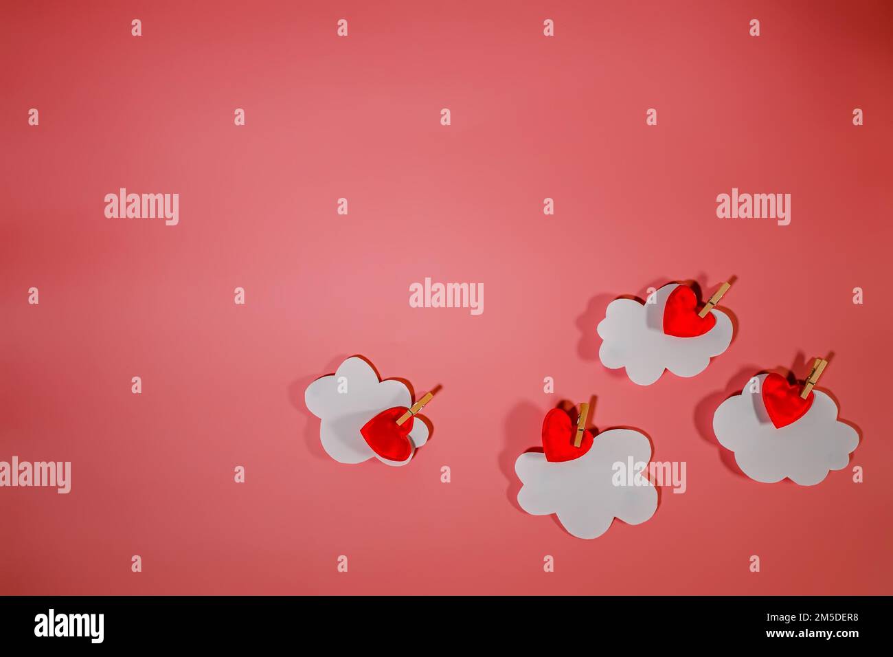 White paper clouds with hearts on linen wooden clothespins. Conceptual ...