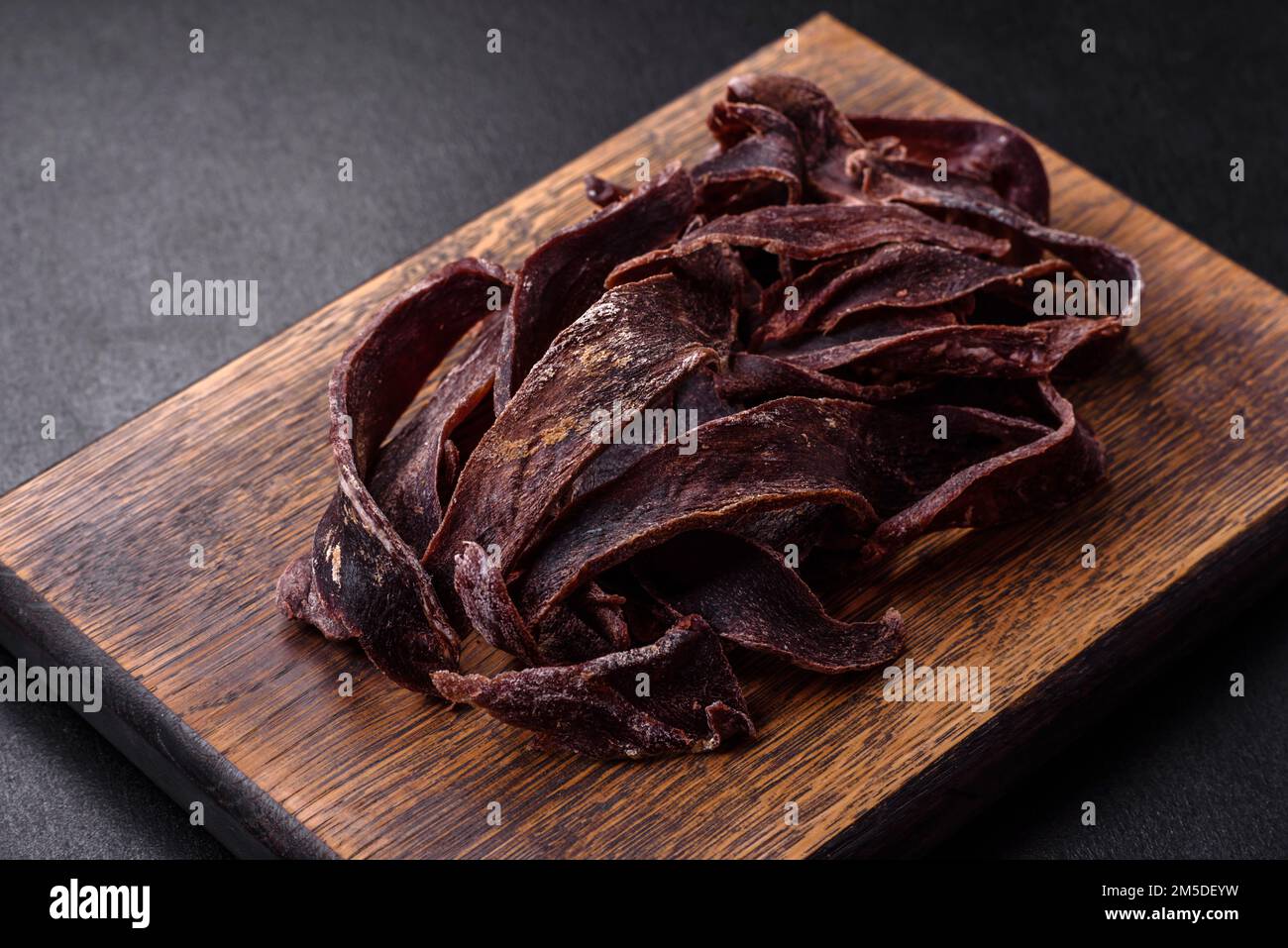 Delicious salted dried beef cut into slices as an appetizer for beer on ...