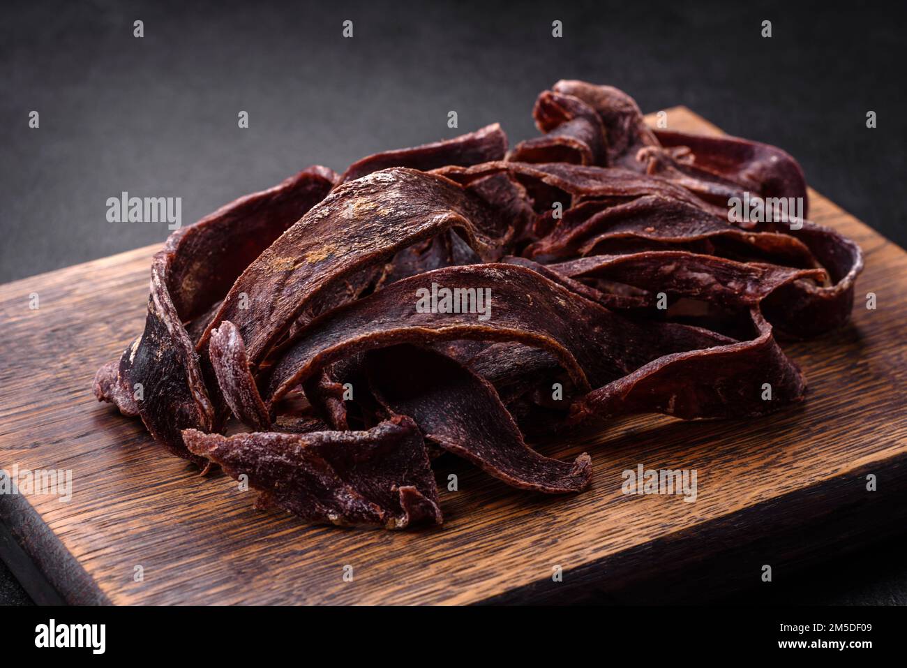 Delicious salted dried beef cut into slices as an appetizer for beer on ...