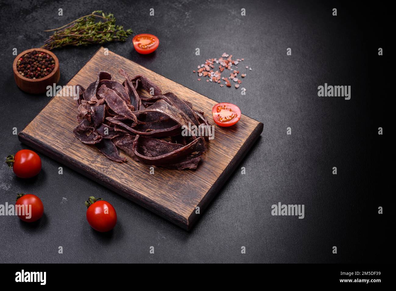 Delicious salted dried beef cut into slices as an appetizer for beer on ...