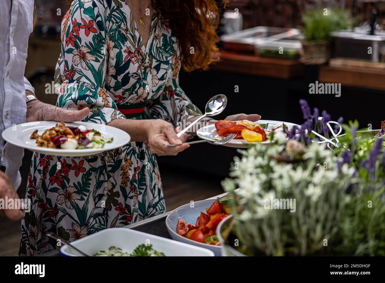 A couple putting food on their plates from a buffet in a restaurant ...