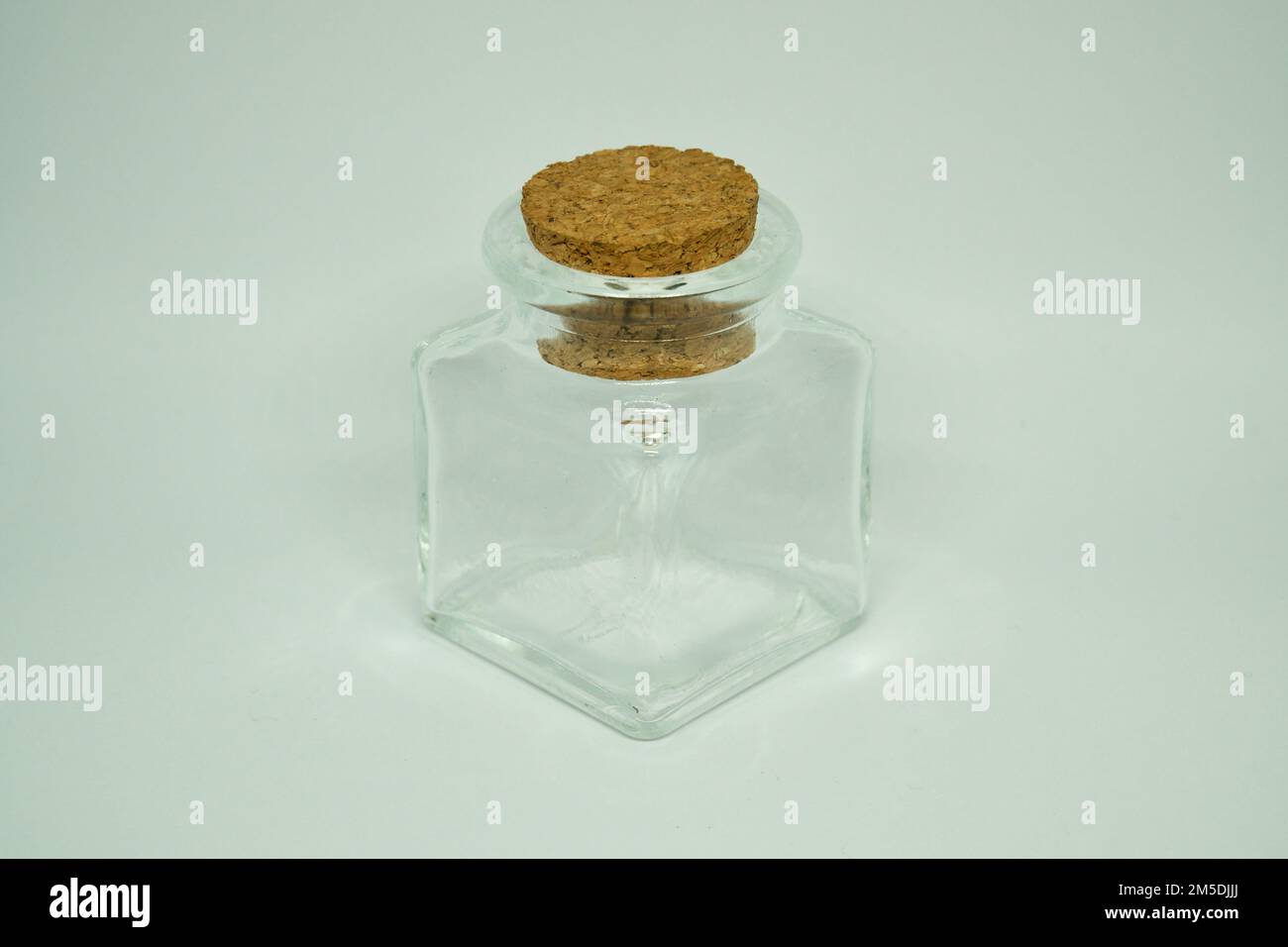 A closeup shot of a small glass jar with a cork lid isolated on a white ...
