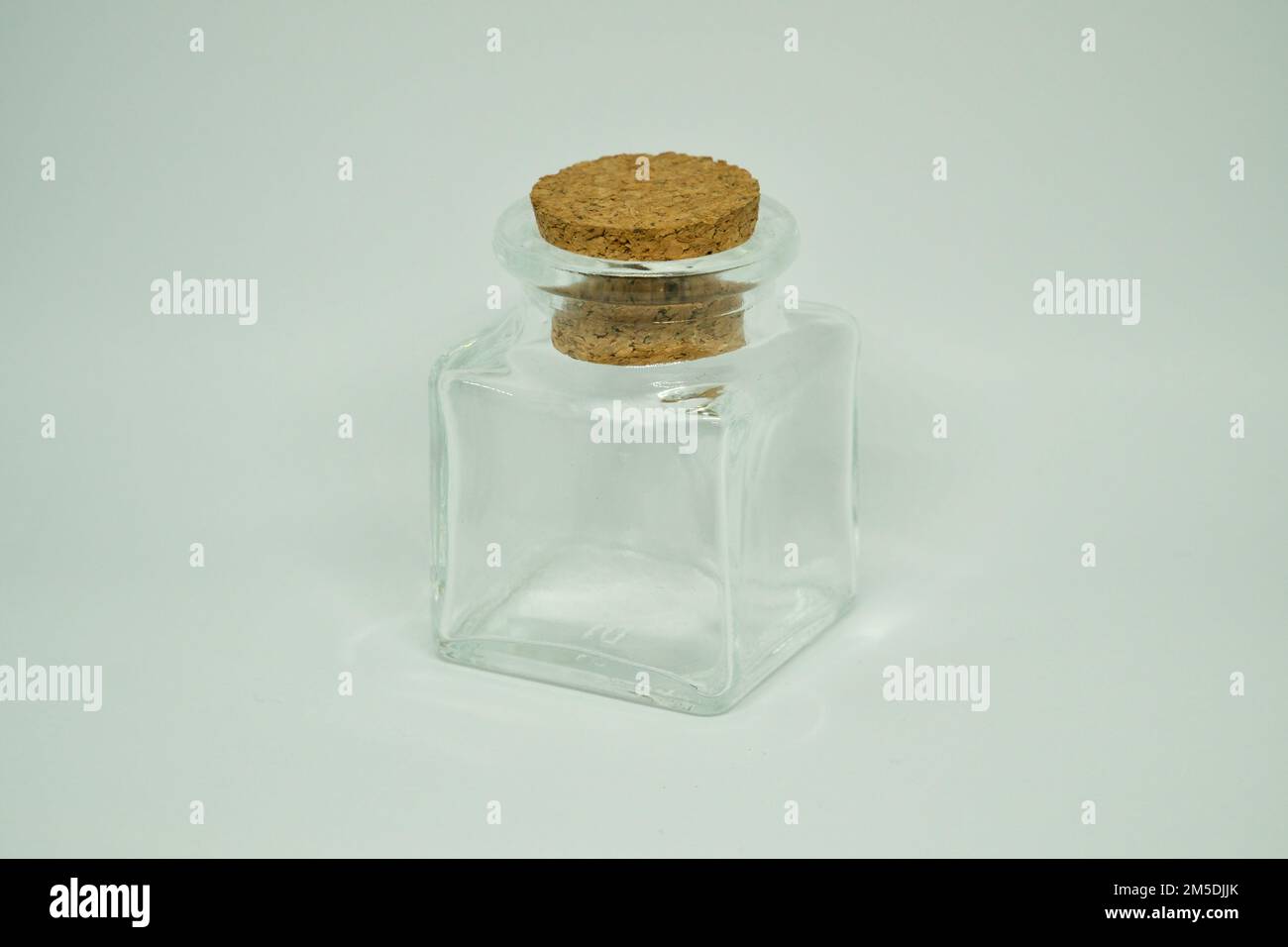 A closeup shot of a small glass jar with a cork lid isolated on a white ...