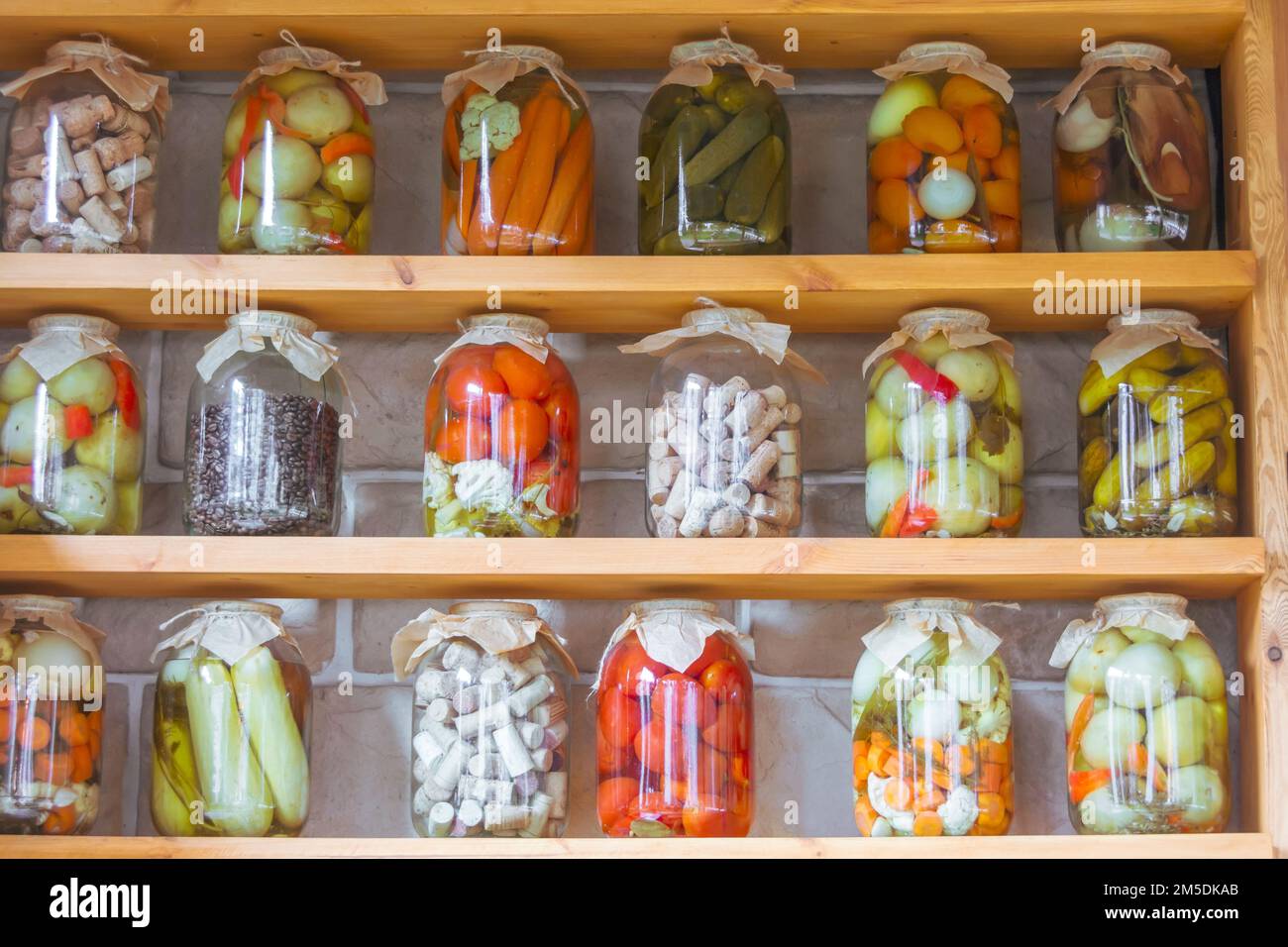 Pickled vegetables, dry coffee, bottle caps in glass jars on storage ...
