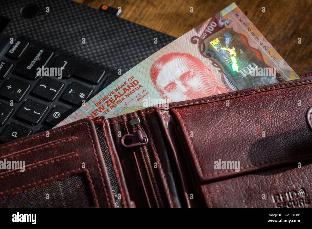 New Zealand money, a wallet full of dollars lying on a computer ...