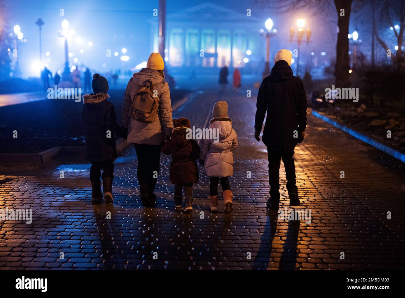 Back of family walking in night foggy city Stock Photo - Alamy