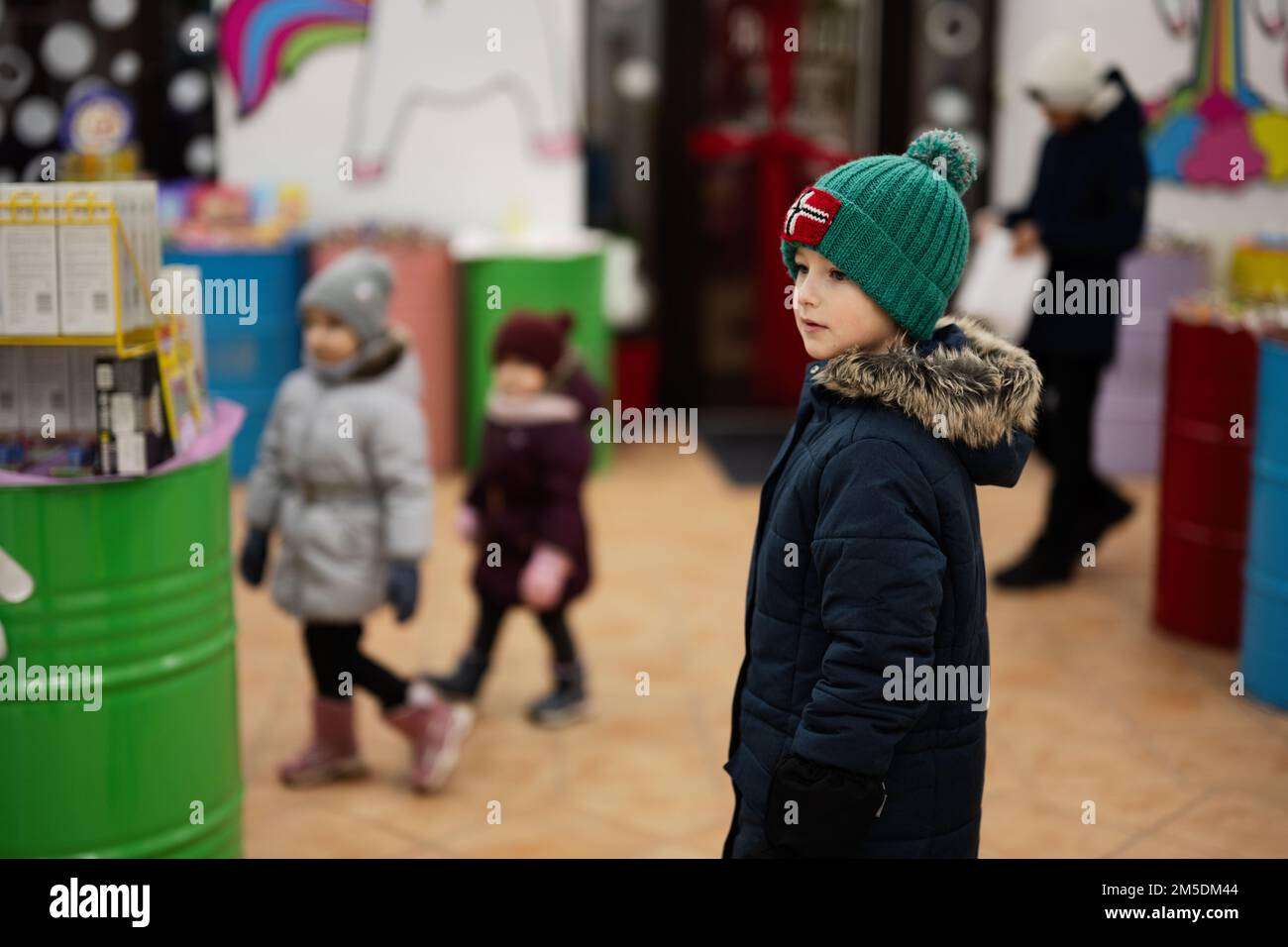 Happy little kids in a candy store chooses sweets, marmalade candies ...