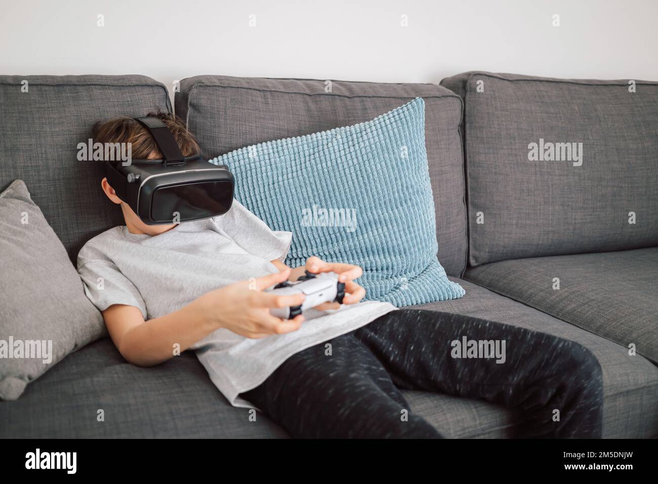 Boy having fun playing simulation games, using virtual reality headset ...