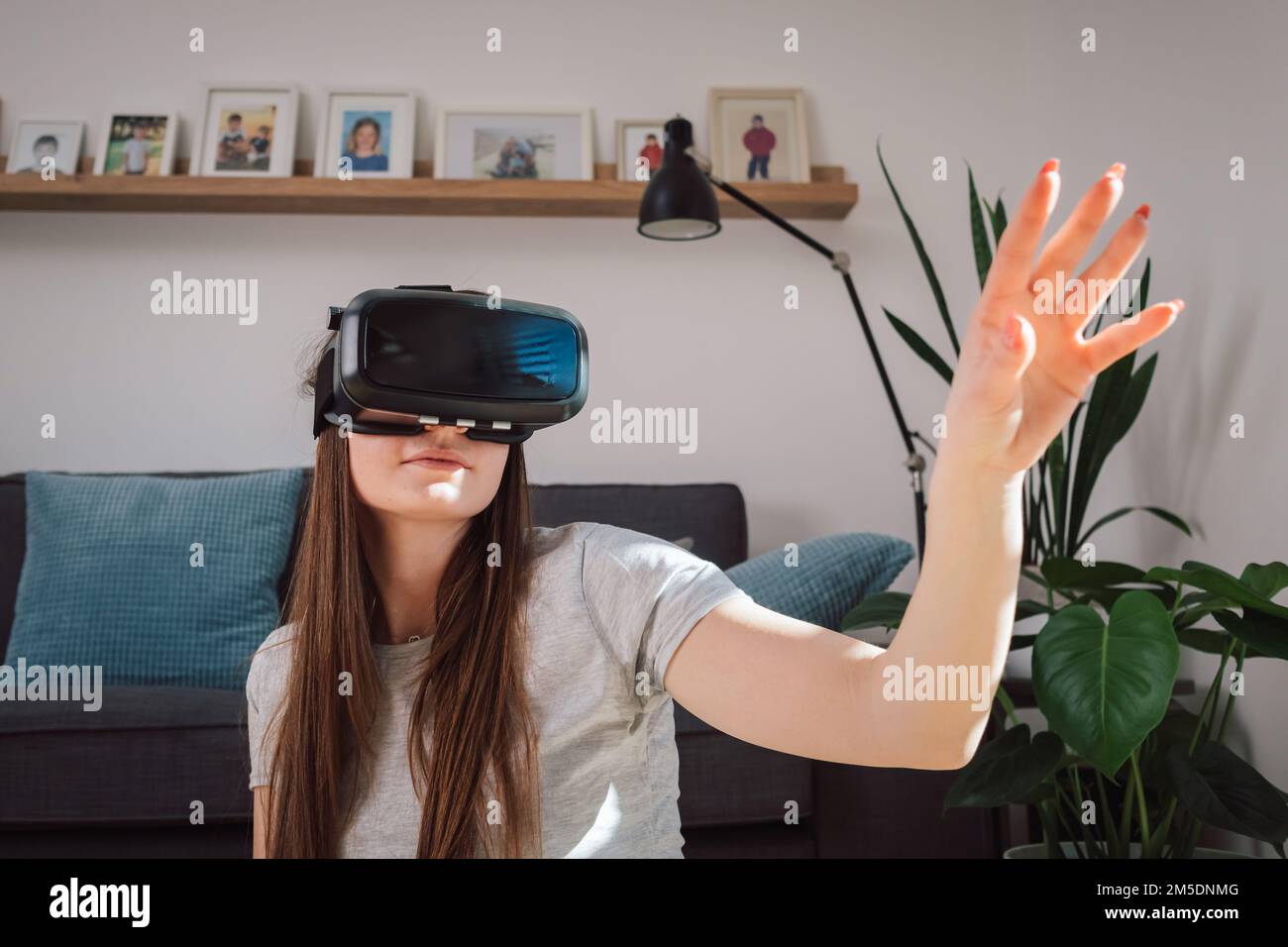 Young woman using virtual reality equipment, VR glasses, to look around ...
