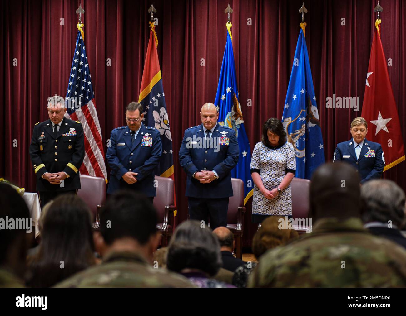 Members of the official party observe a solemn moment of prayer at a ...