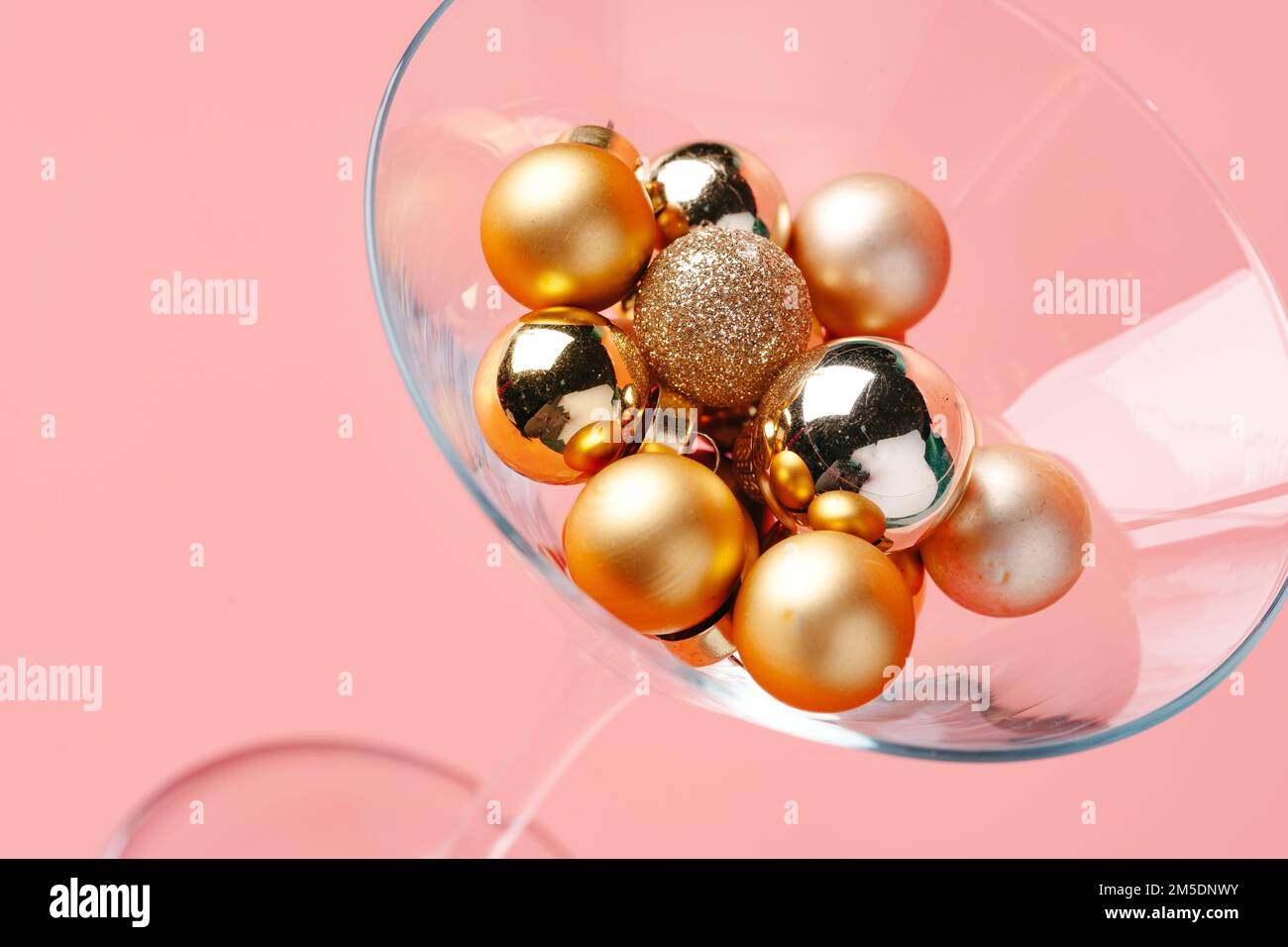 Glass with Christmas decorations on pink pastel background Stock Photo ...