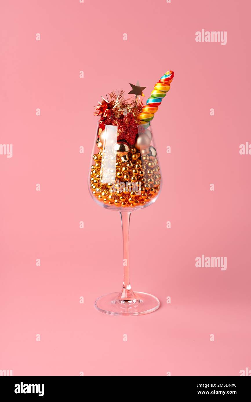 Glass with Christmas decorations on pink pastel background Stock Photo ...
