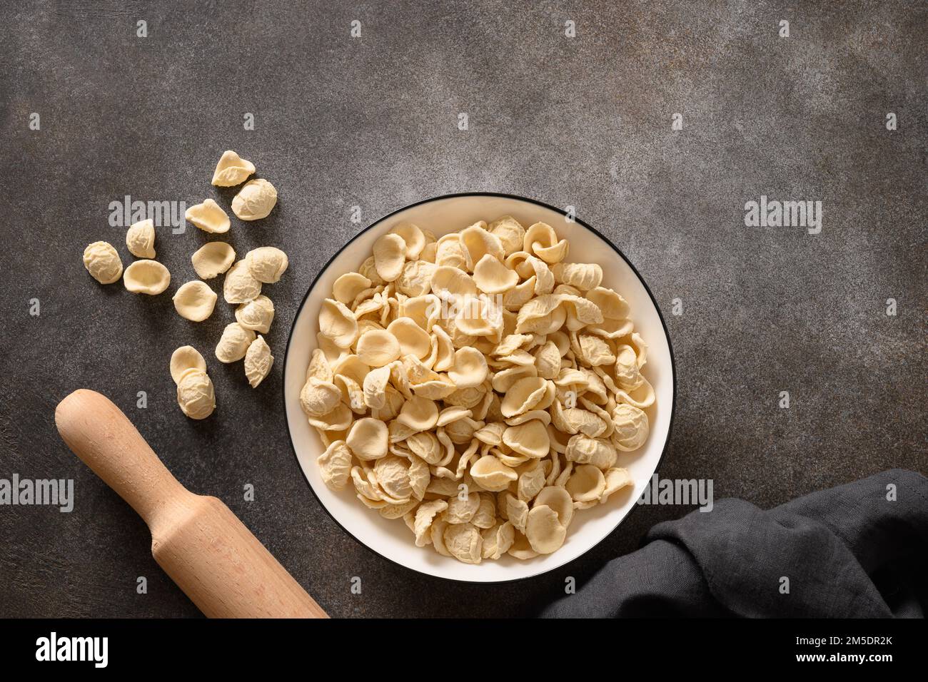 Raw apulian Orecchiette pasta made from whole wheat flour on dark ...