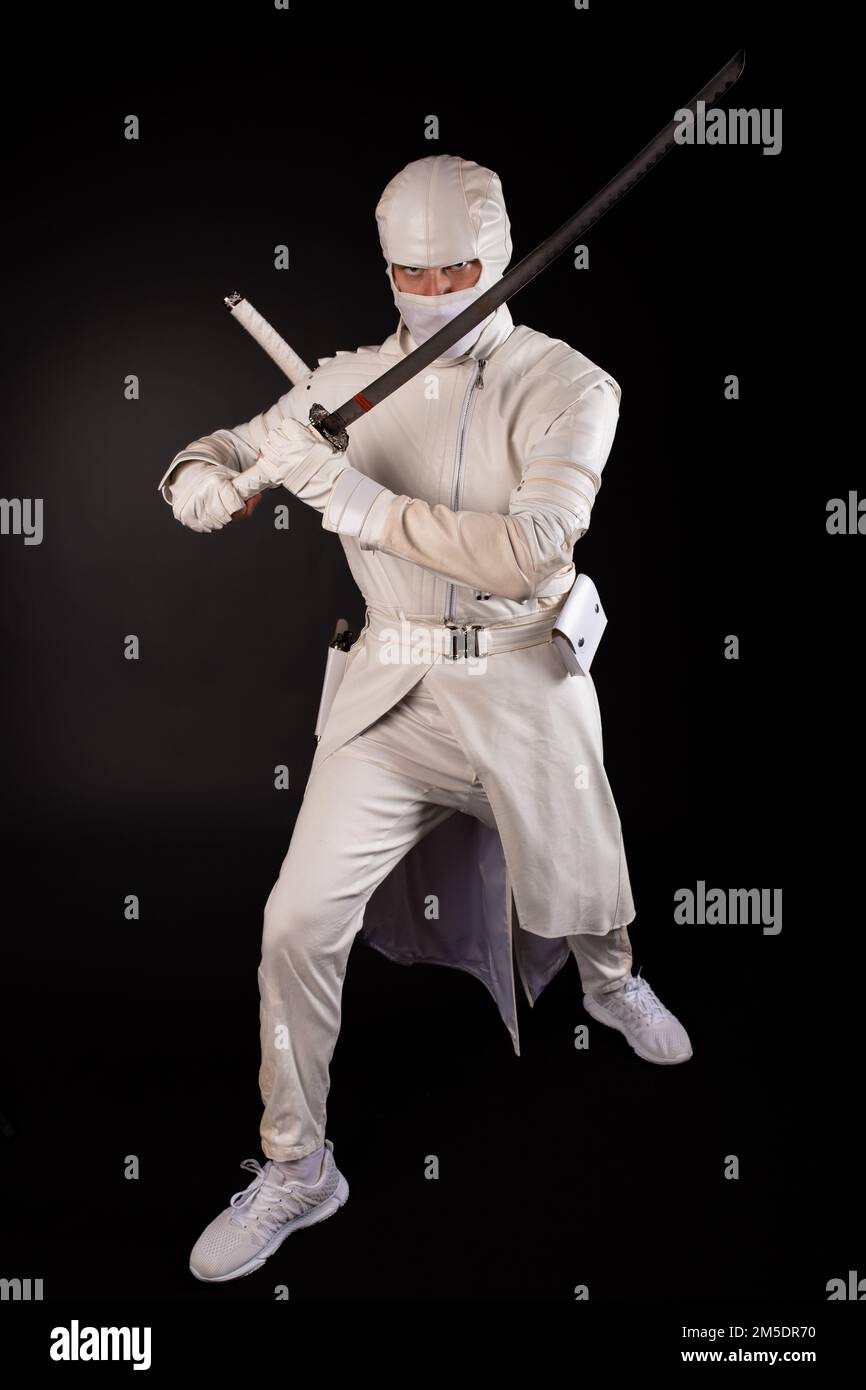 Combat ninja posing with a sword on a black background Stock Photo - Alamy