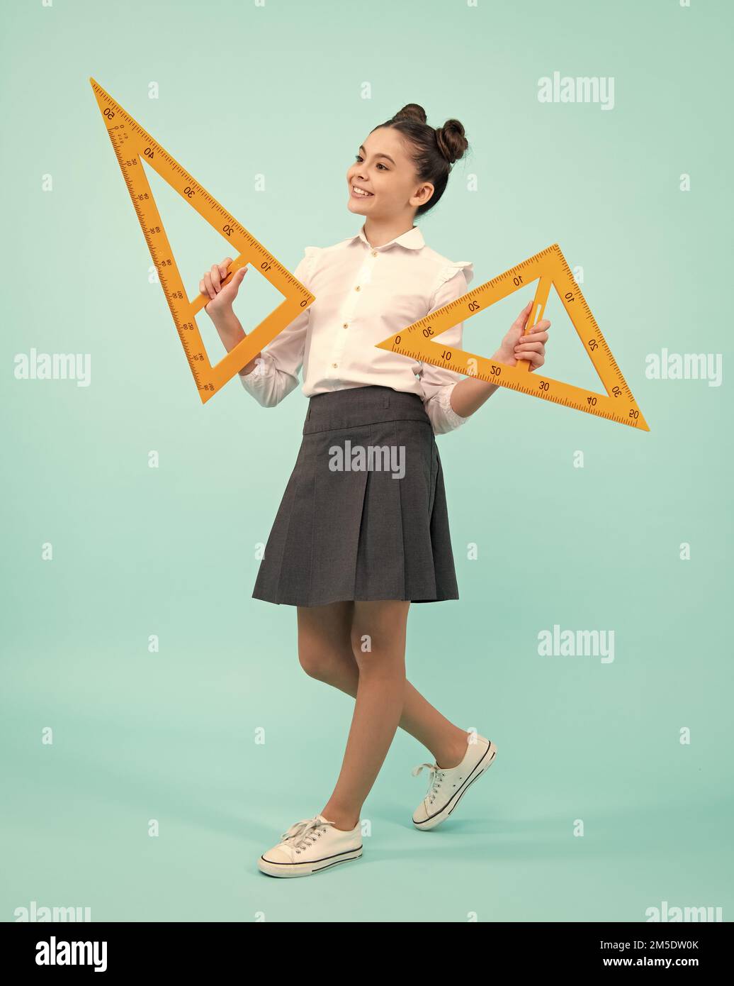Back to school. School girl hold ruler measuring isolated on blue ...