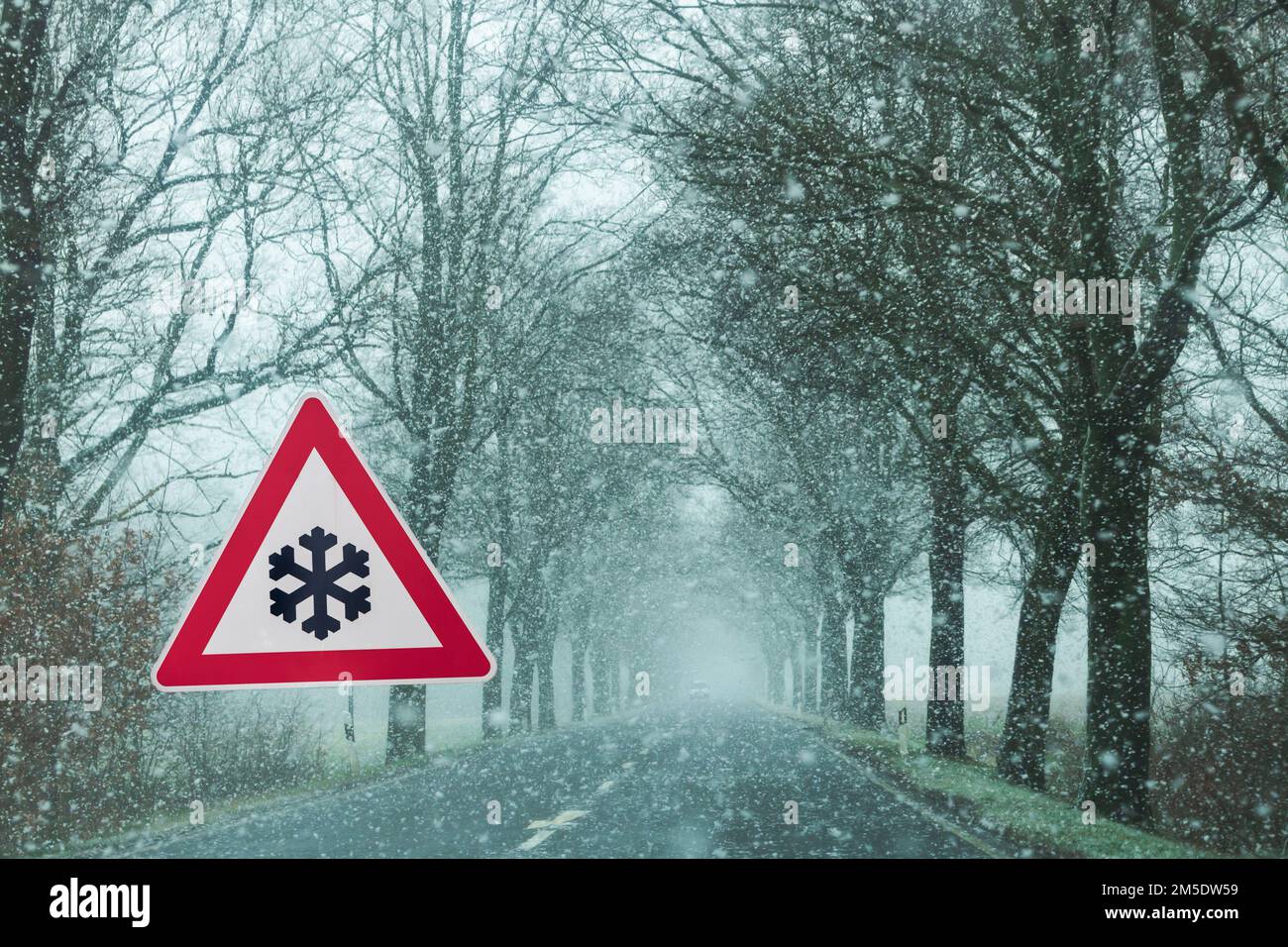 Traffic sign Caution Snowfall, slippery due to snow Stock Photo - Alamy