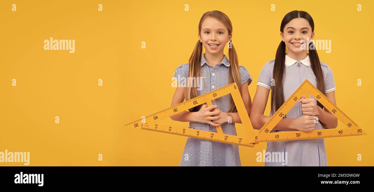 School girls friends. Happy kids hold triangular rulers. Geometry ...