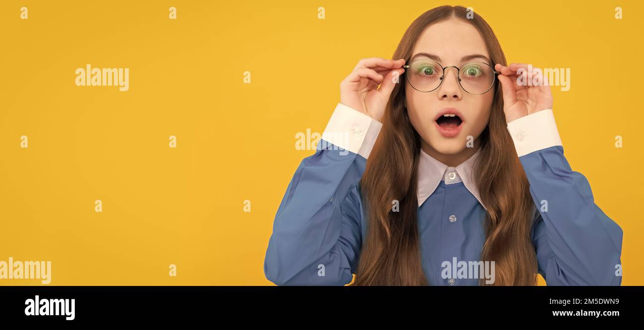 Shocked school aged girl child in spectacles with amazed look yellow ...