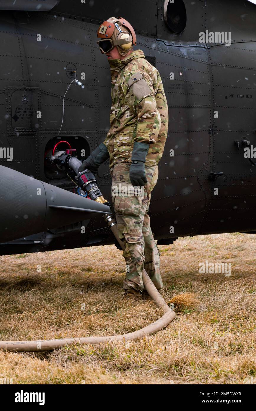 A U.S. Soldier refuels a UH-60 Black Hawk helicopter at a forward ...